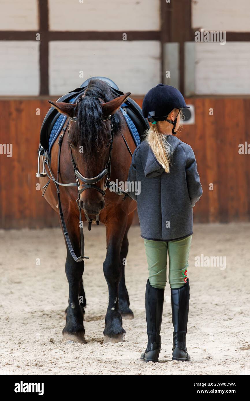 Horse riding school. Little children girls at group training equestrian ...