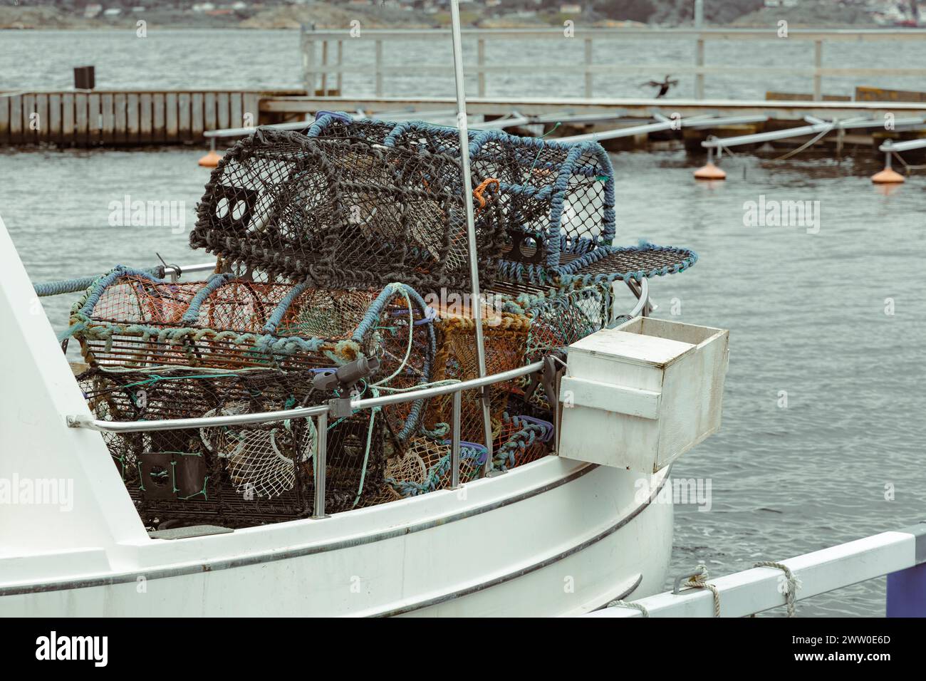 Fish traps stacked on boat with sea and harbour background Stock Photo ...