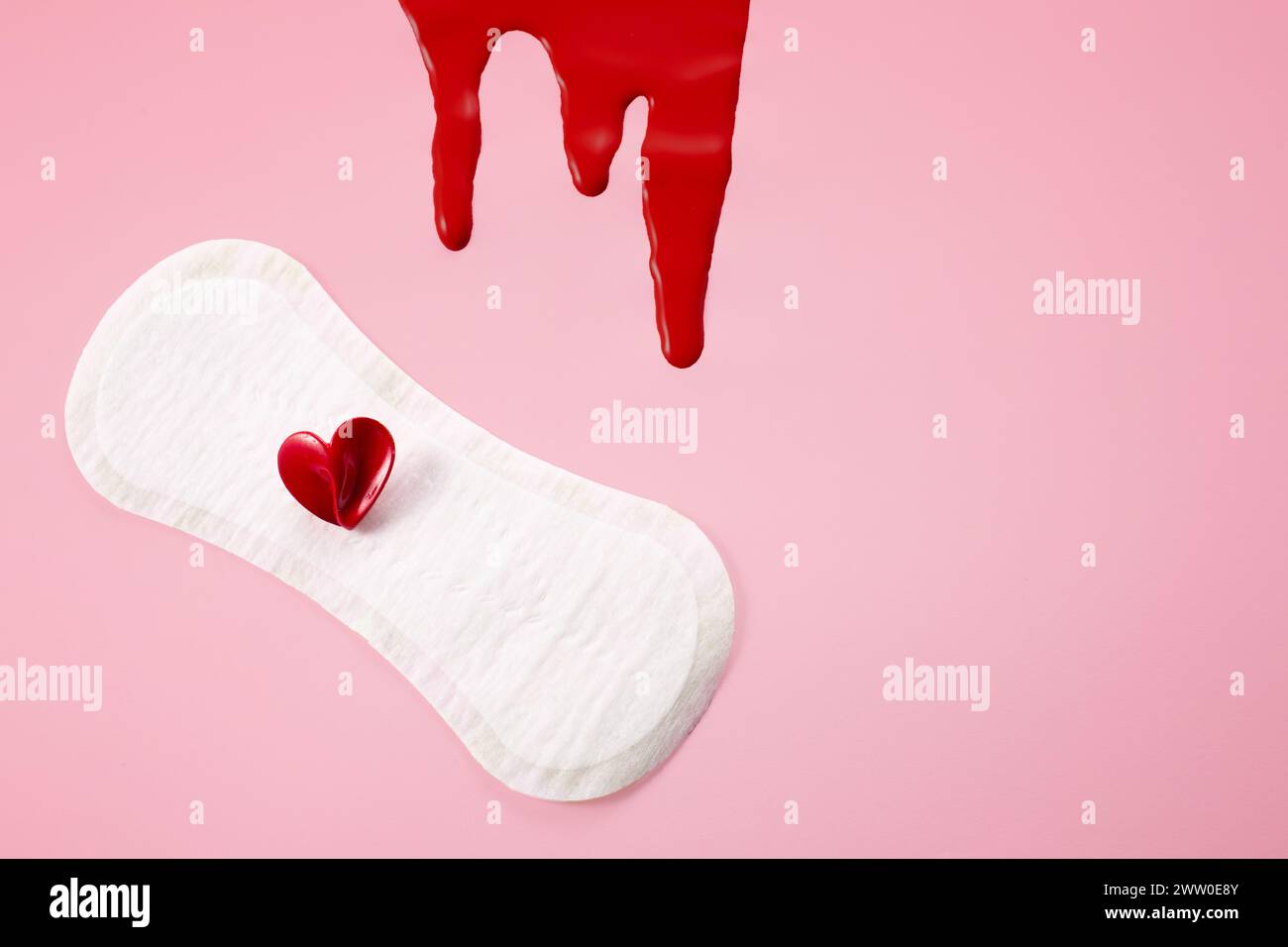 Blood, feminine hygiene pad with red heart on pink background. First ...