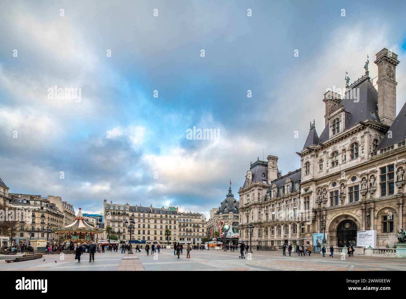 Dusk view of the bustling Hôtel de Ville Square, with pedestrians and ...