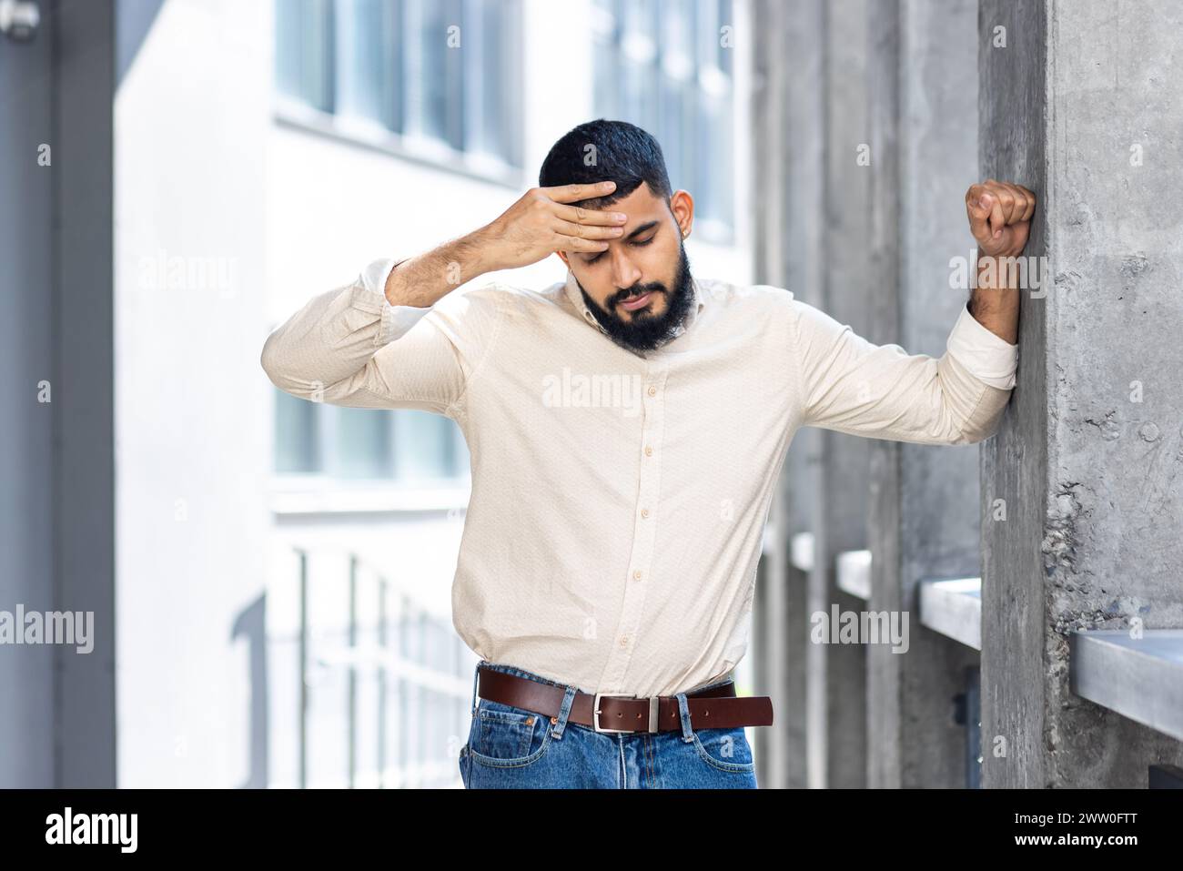 A photo capturing an adult man in casual wear leaning against a rough ...