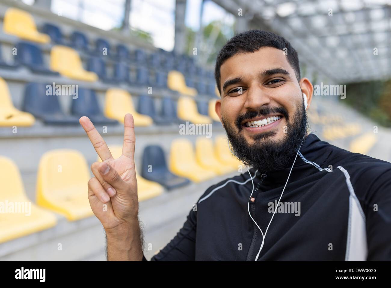 Young man giving peace sign hi-res stock photography and images - Alamy