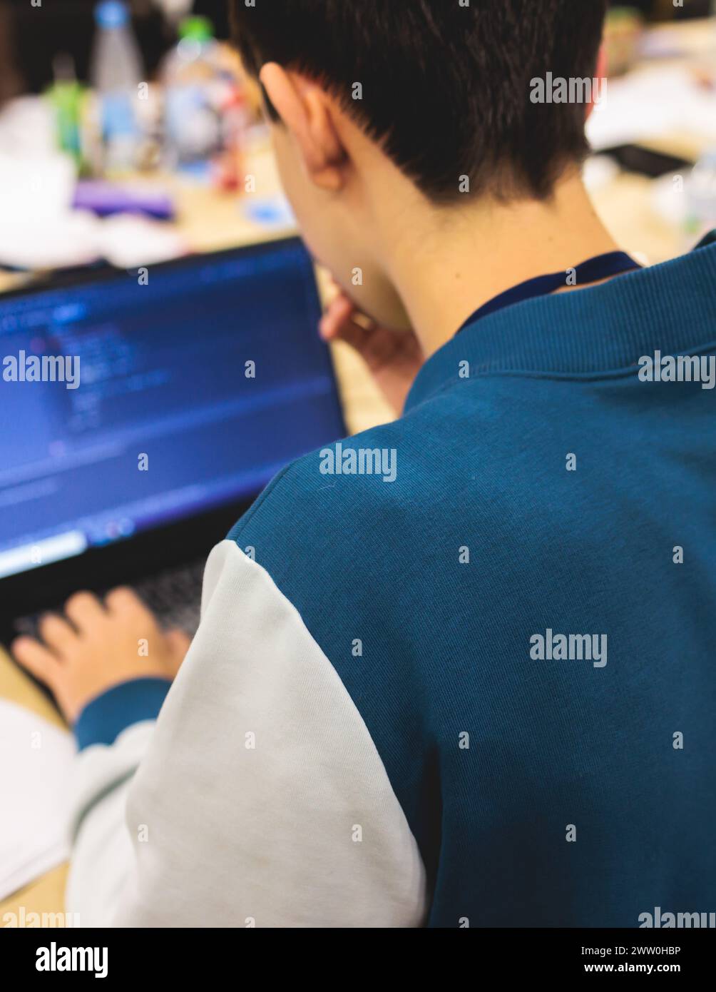 Software developer students in auditorium hall working on computer and ...