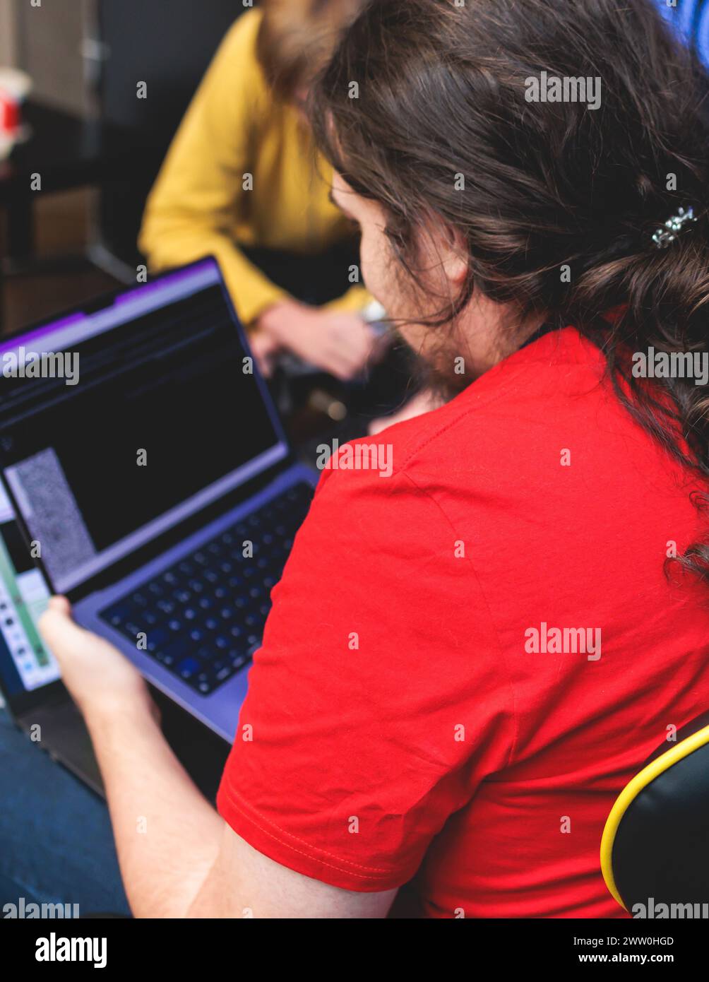 Software developer students in auditorium hall working on computer and ...