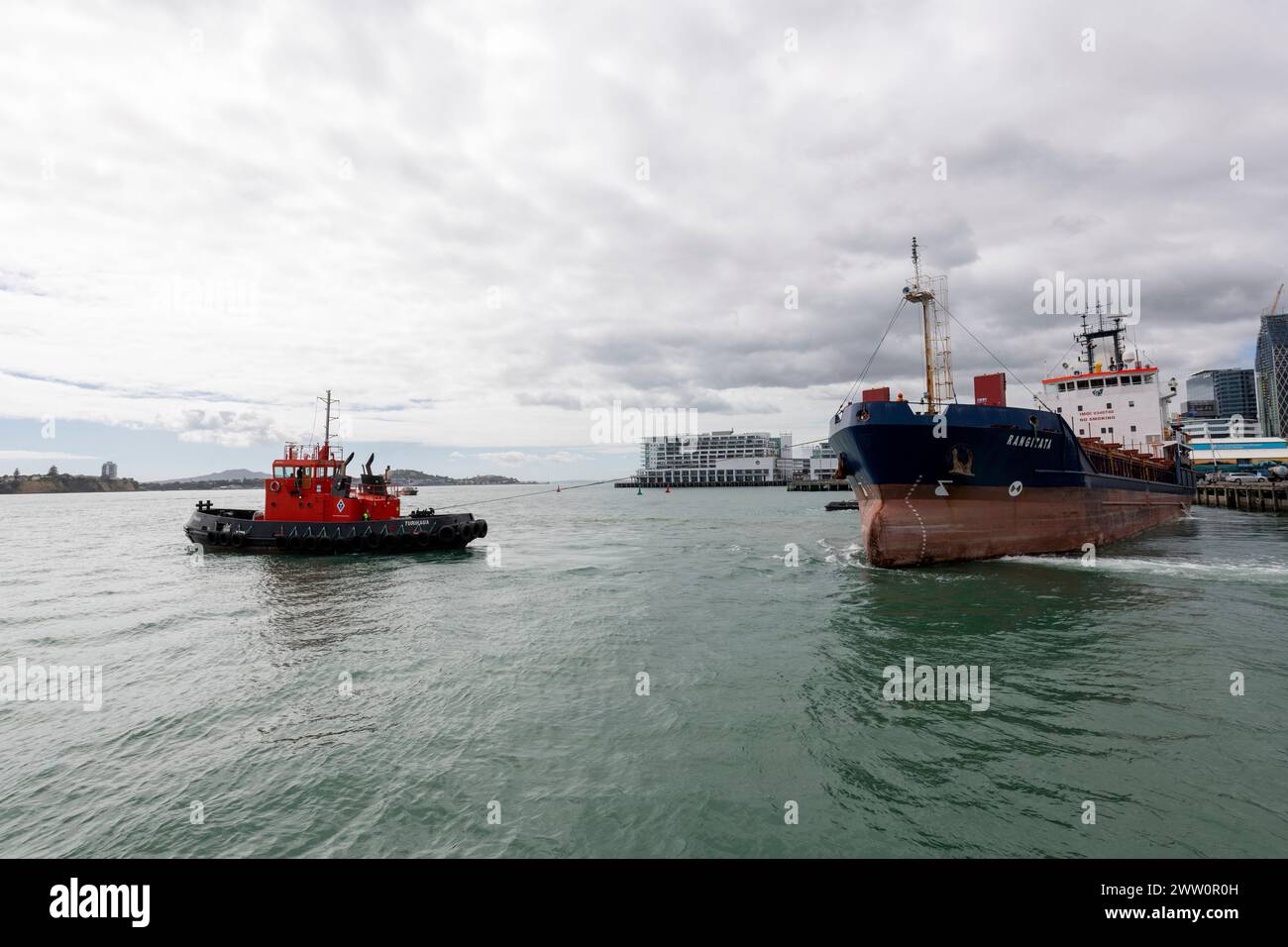 Two tug boats assist the Cargo ship Rangitata to get off the dock at ...