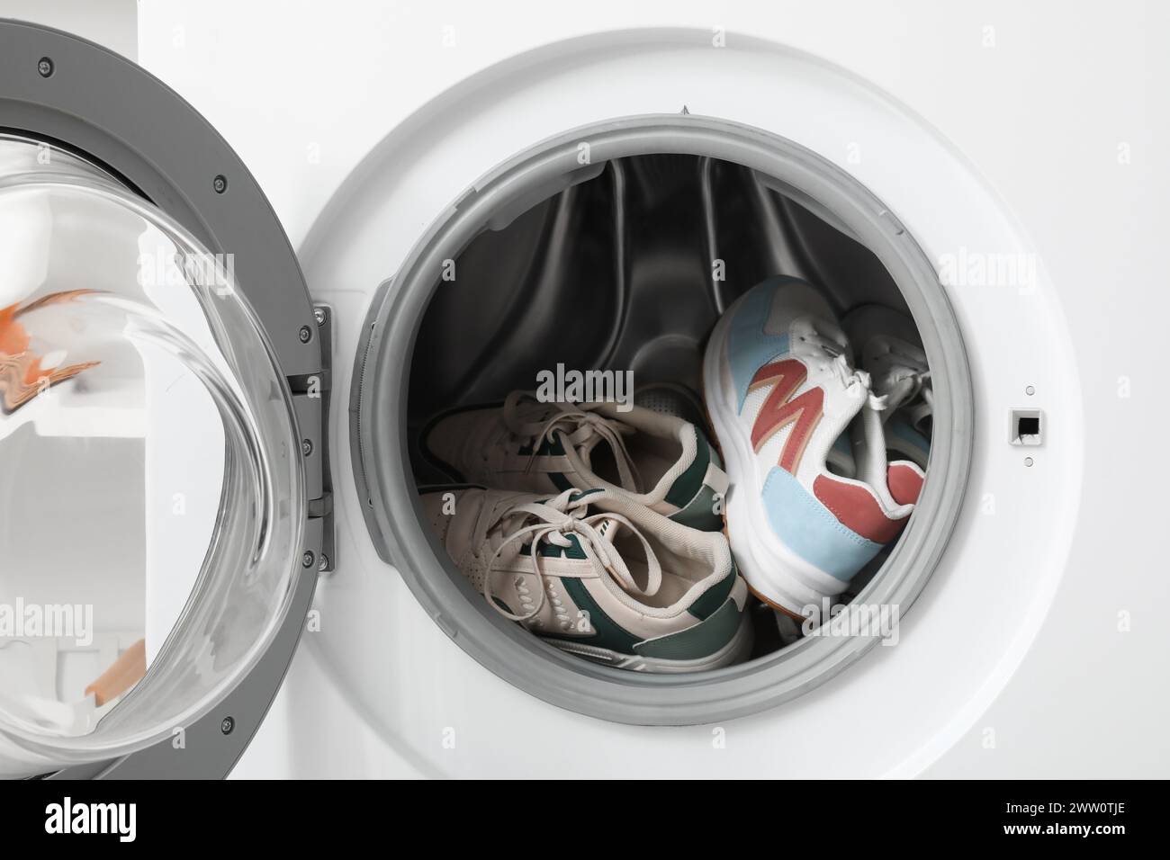 Open washing machine with sneakers, closeup Stock Photo - Alamy