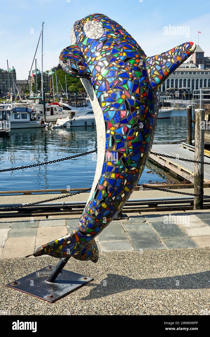 Large colorful, orca whale sculpture, with the ocean and marine vessels ...