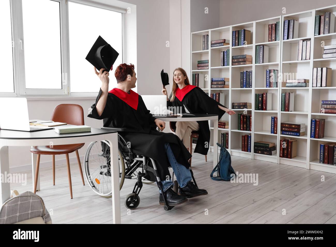 Happy male graduate in wheelchair with classmate at university Stock ...
