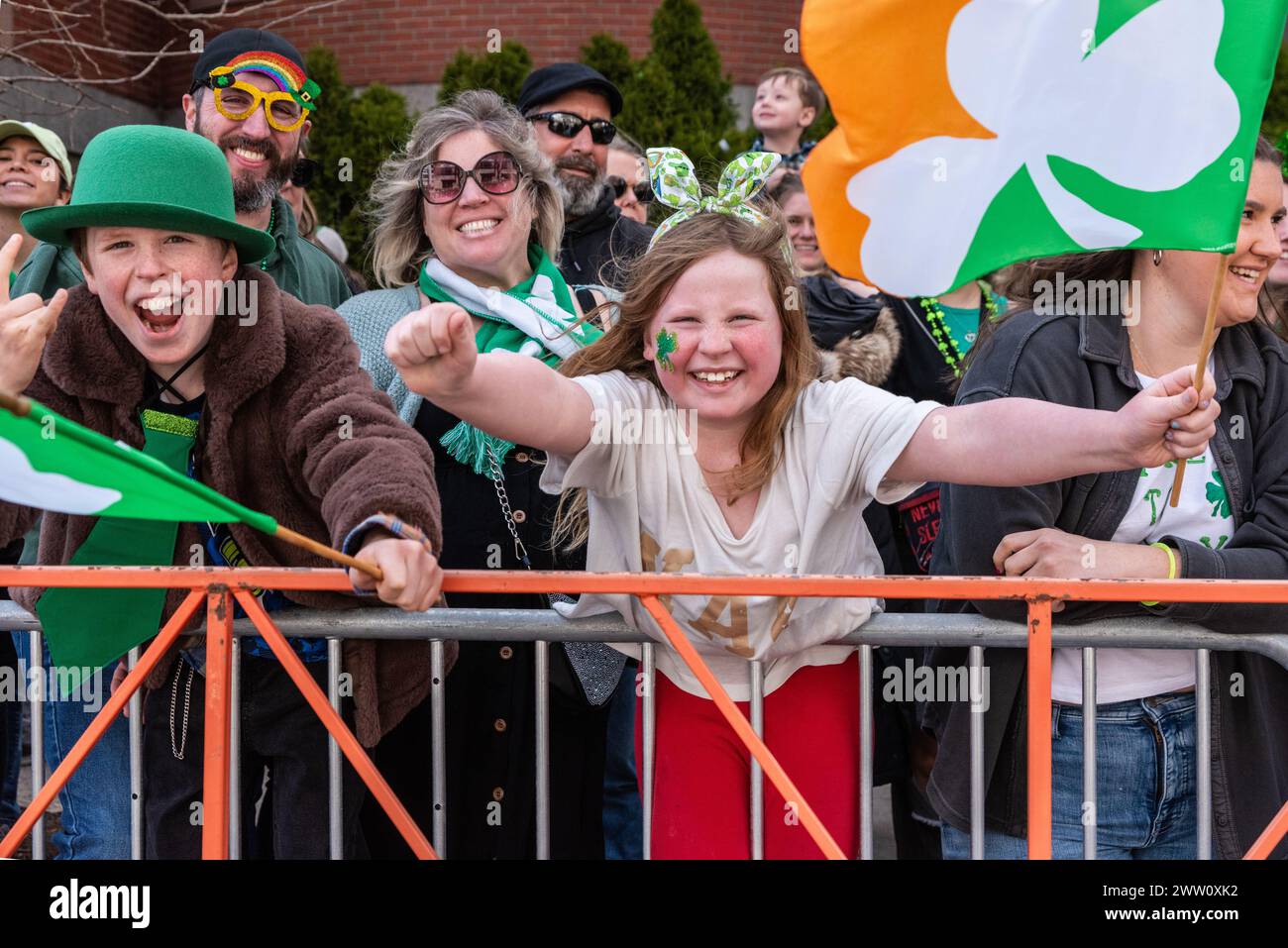 A very excited young girl waving the Irish flag in a crowd of people at ...