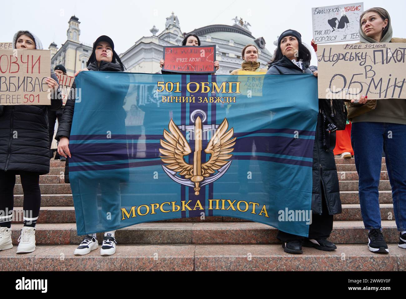 Ukrainian women hold a flag of the 501th Marine Battalion, defenders of ...