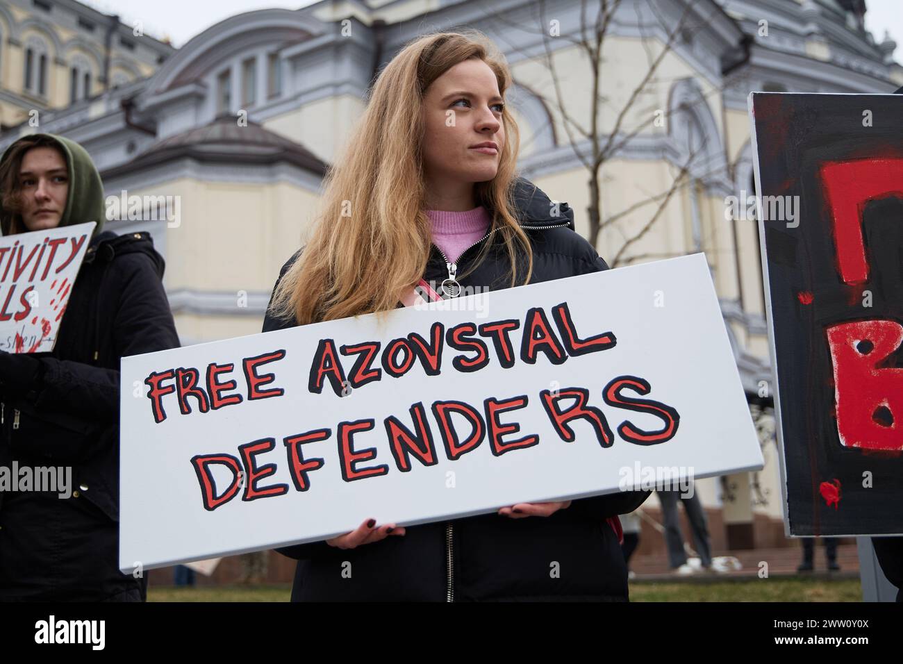 Ukrainian woman shows a banner "Free Azovstal Defenders" on a rally ...
