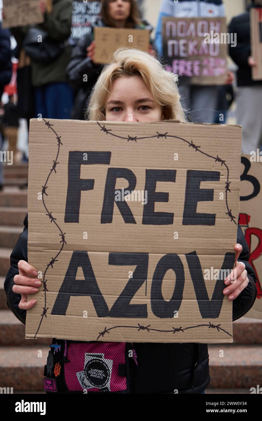 Young Ukrainian female posing with a poster "Free Azov" on a rally for release of captured ...