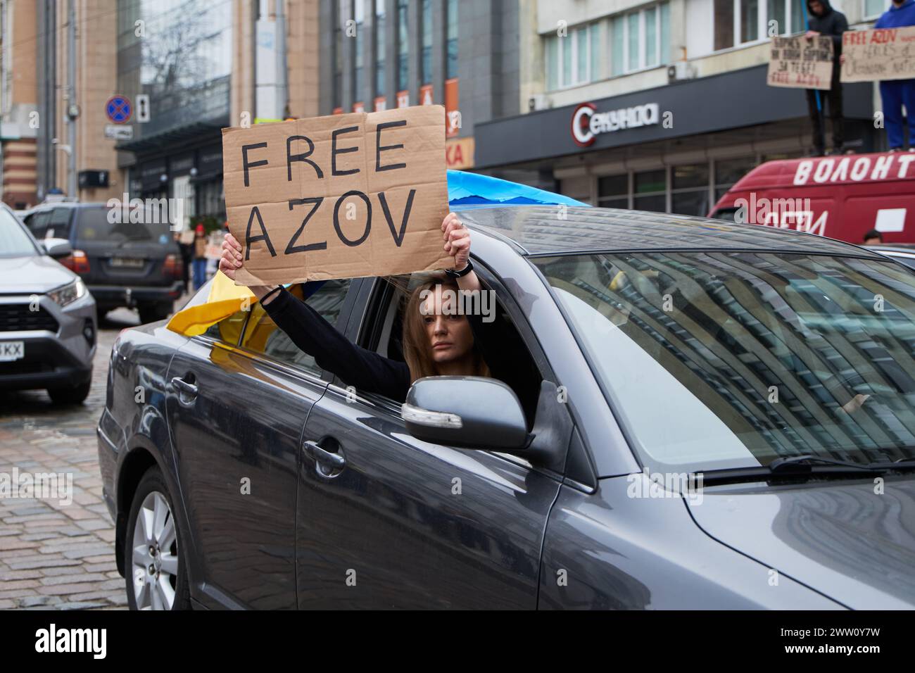 Ukrainian woman shows a banner "Free Azov" out of a moving vehicle on a ...