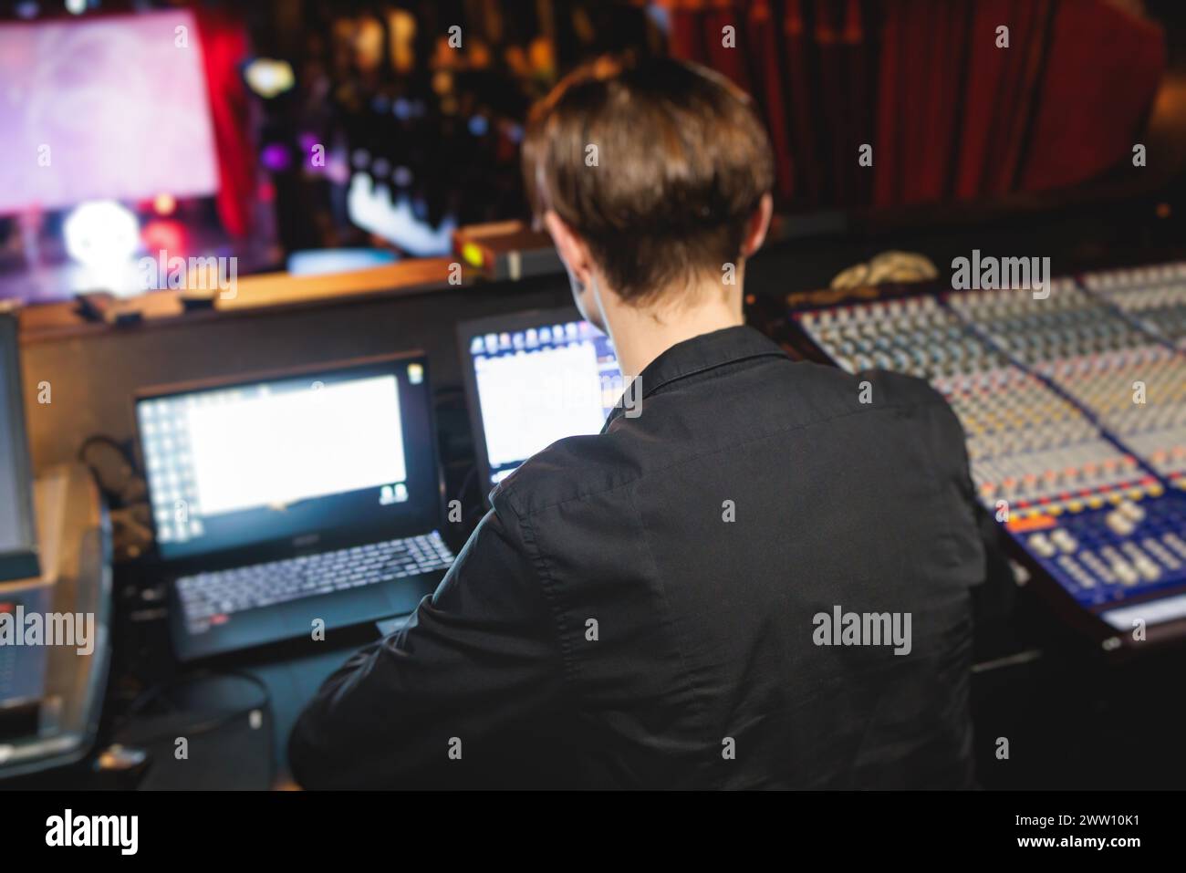 View of lighting technician operator working on mixing console ...