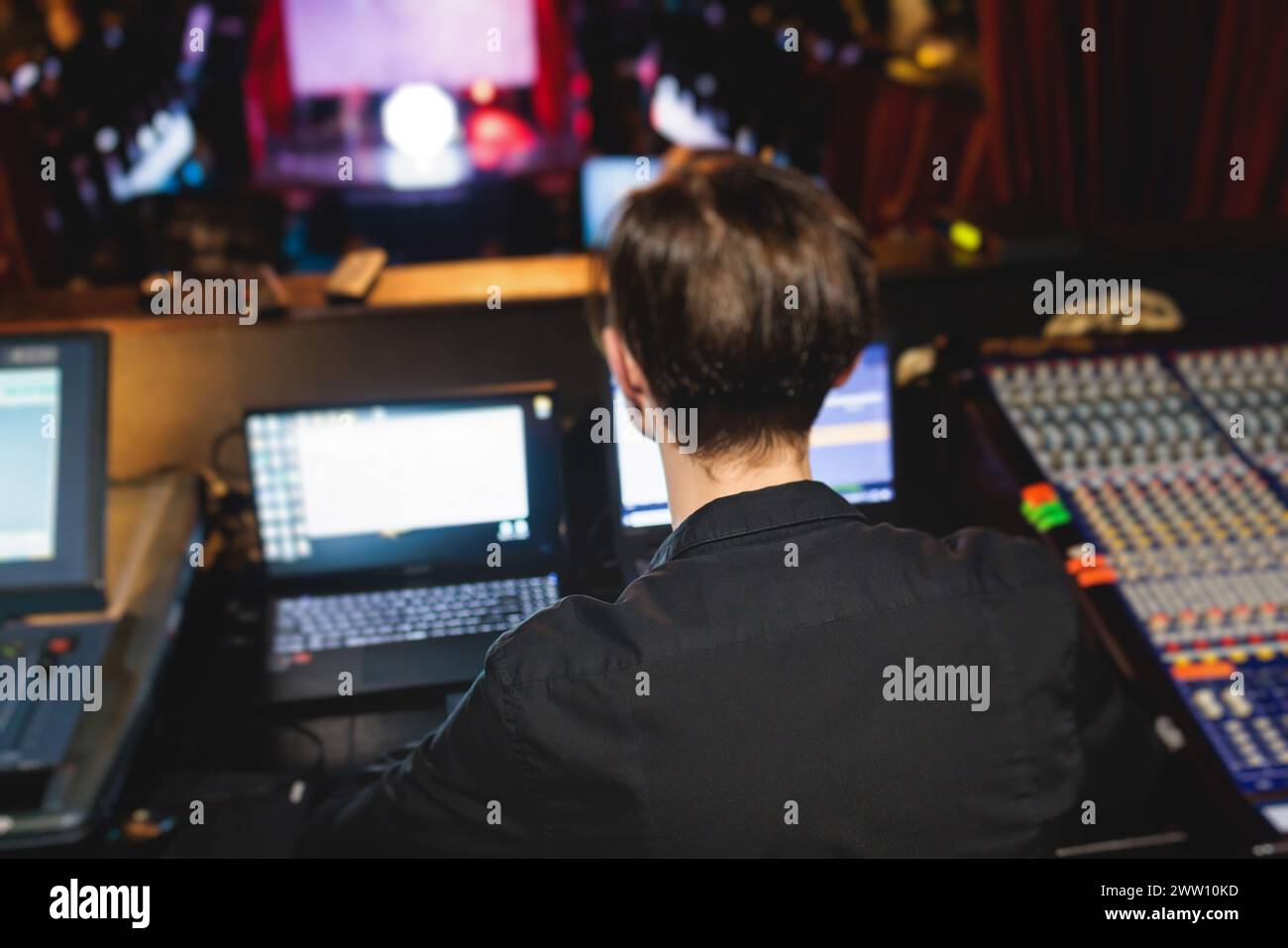 View of lighting technician operator working on mixing console ...
