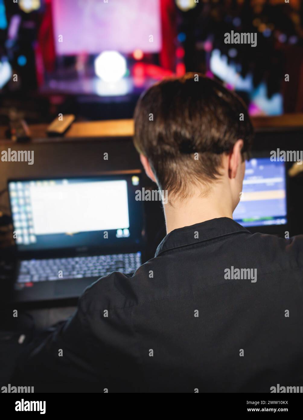 View of lighting technician operator working on mixing console ...