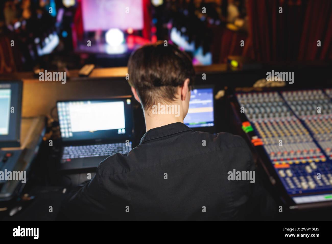 View of lighting technician operator working on mixing console ...