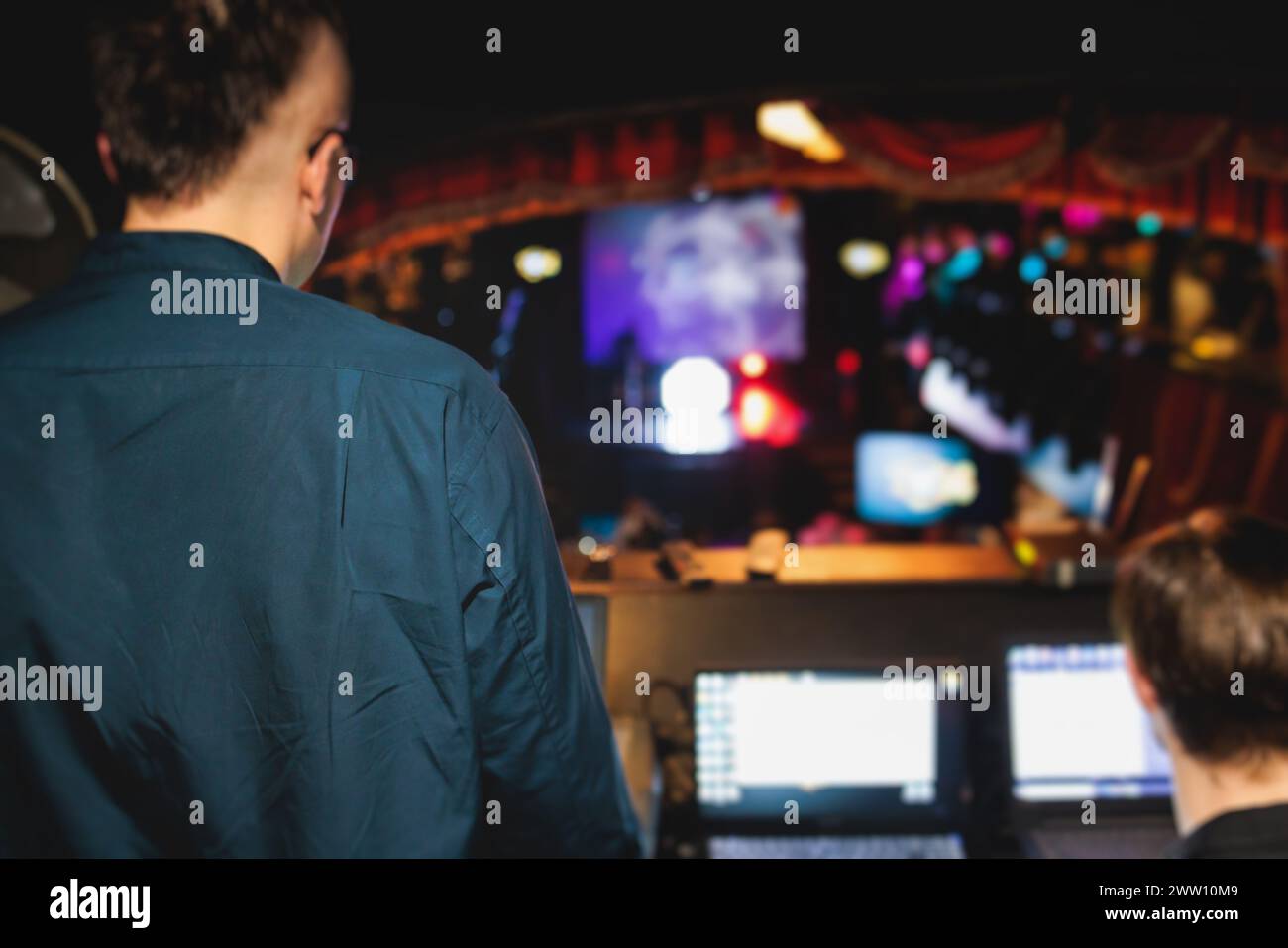 View of lighting technician operator working on mixing console ...