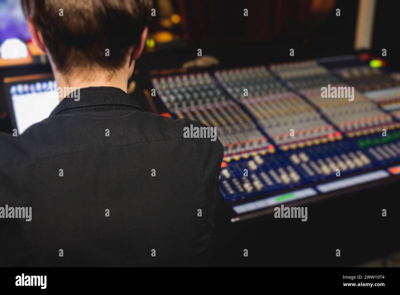 View of lighting technician operator working on mixing console ...