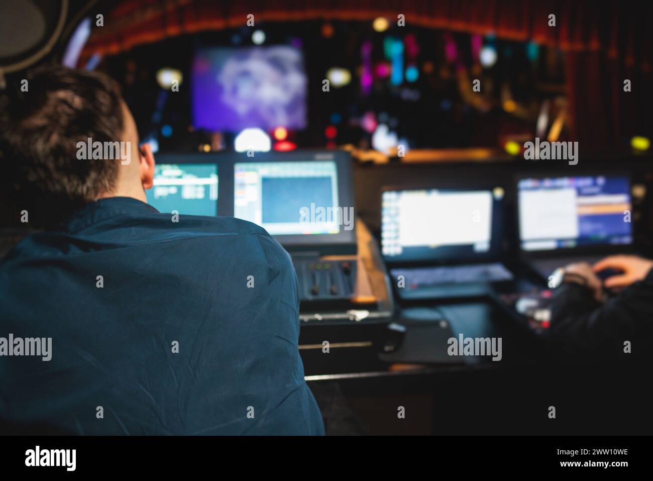 View of lighting technician operator working on mixing console ...