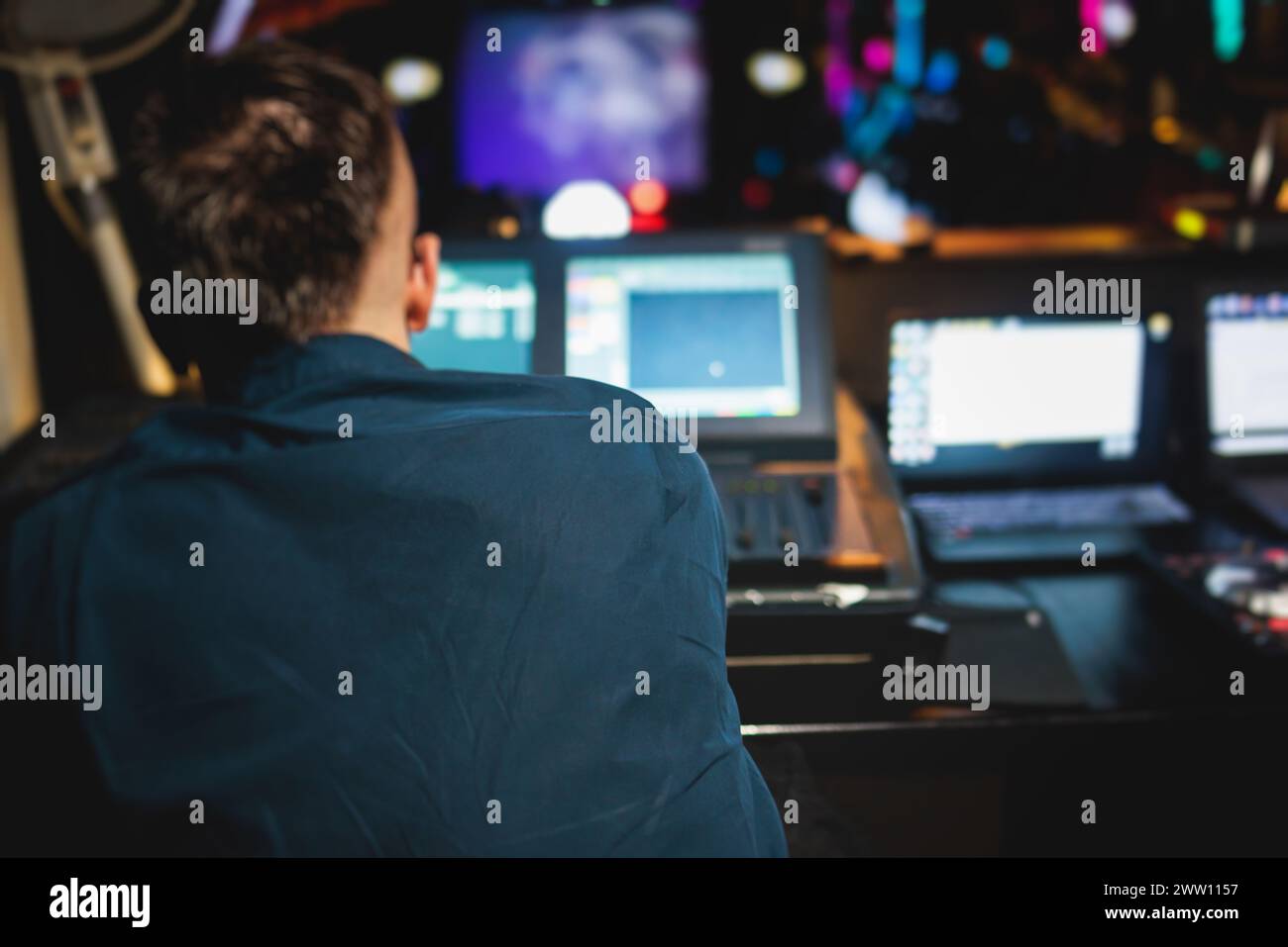View of lighting technician operator working on mixing console ...