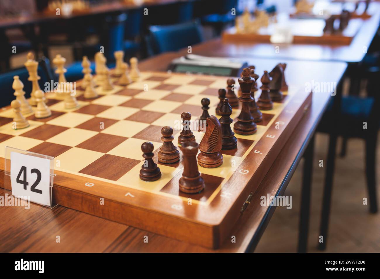 Chess tournament, kids and adults participate in chess match game outdoors in indoor hall ...