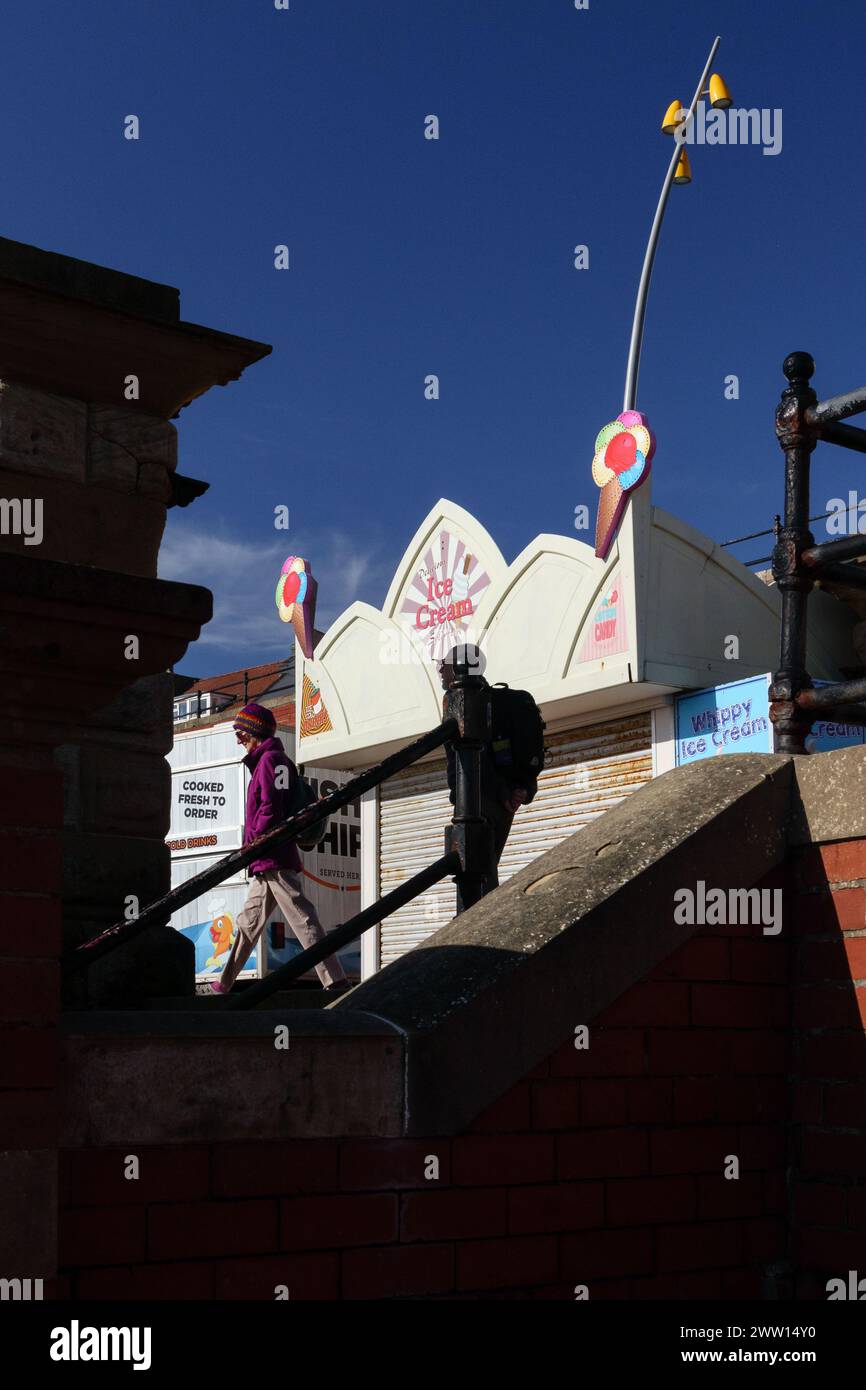 Two men walk past the closed chip shop at Bayside Fun Park in ...