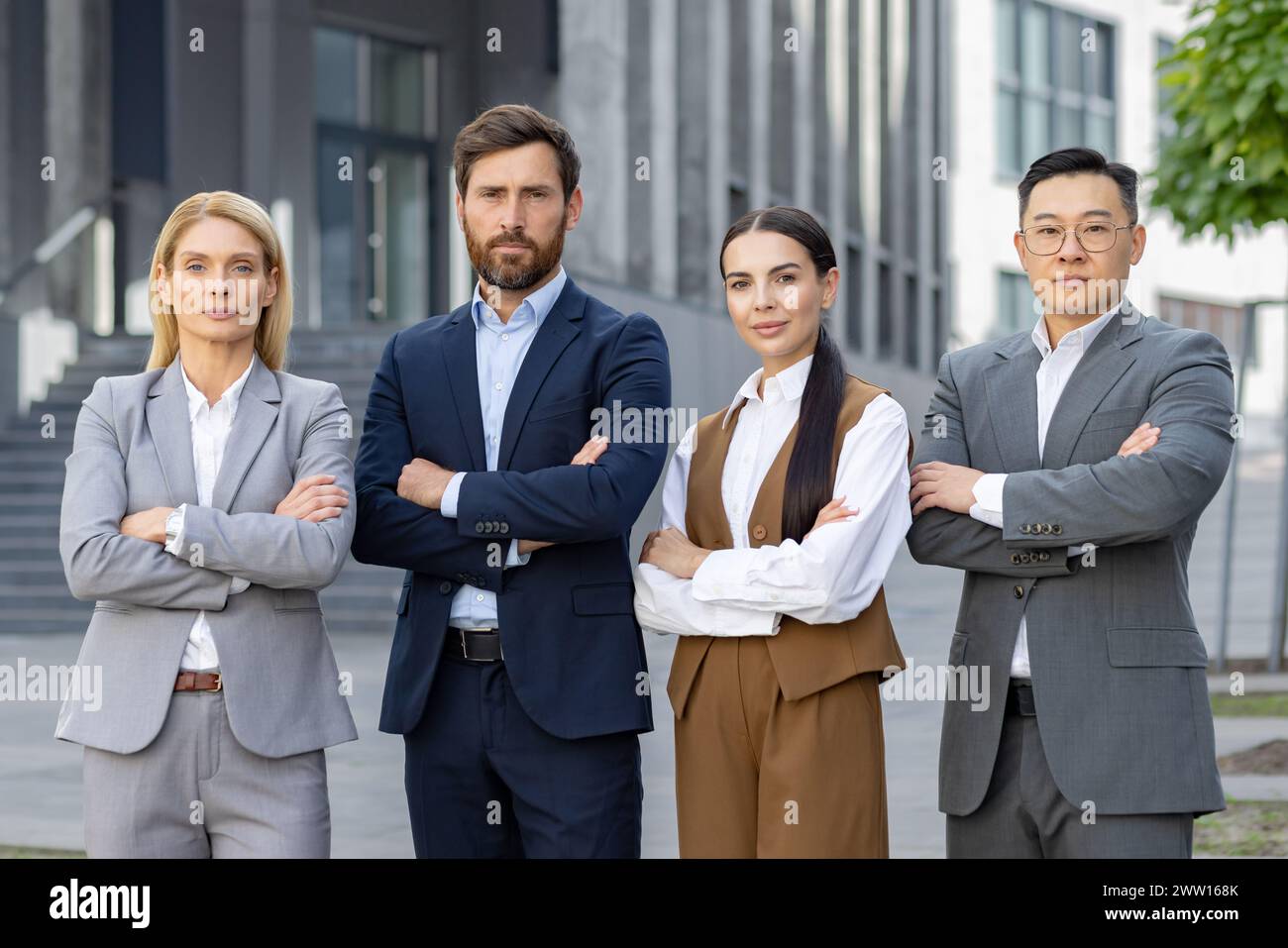 Four professional business individuals posing confidently outdoors ...
