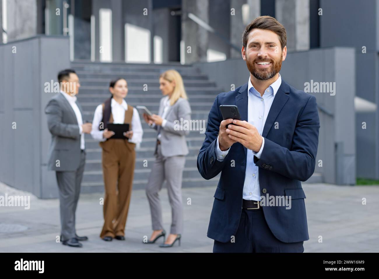 Corporate professionals engaged with smartphones during a break outside ...
