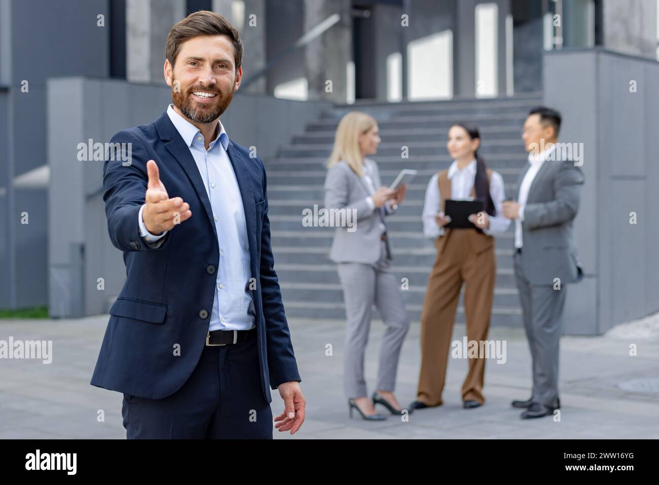 A professional businessman extending his hand for a handshake in front ...