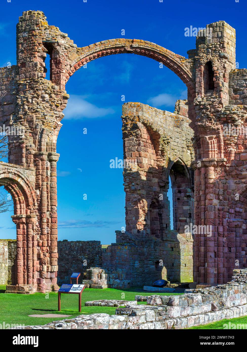 A daytime view in sunshine of Lindisfarne Priory on the Holy island of ...