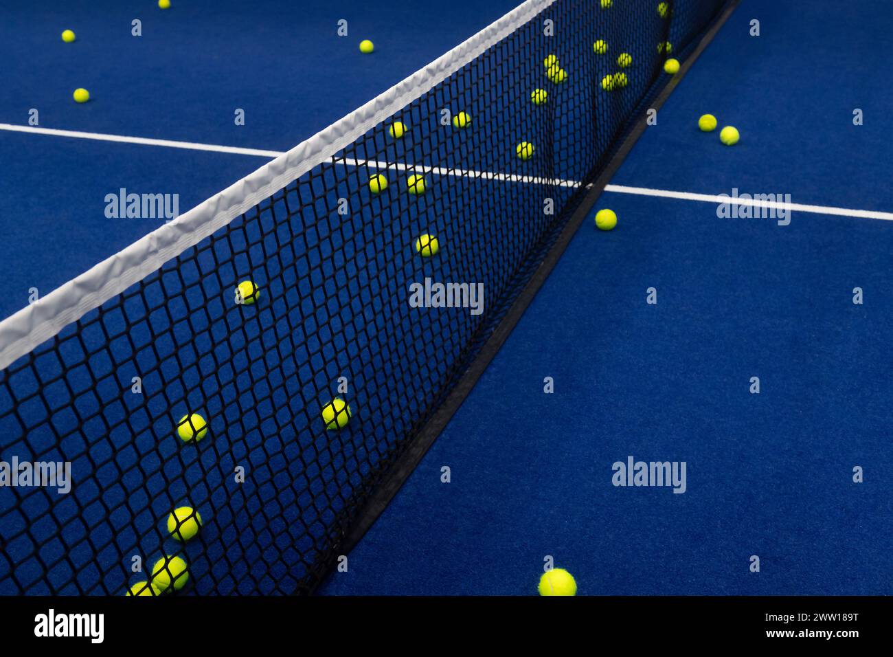 Yellow tennis and padel balls in court on blue turf. Horizontal sport ...