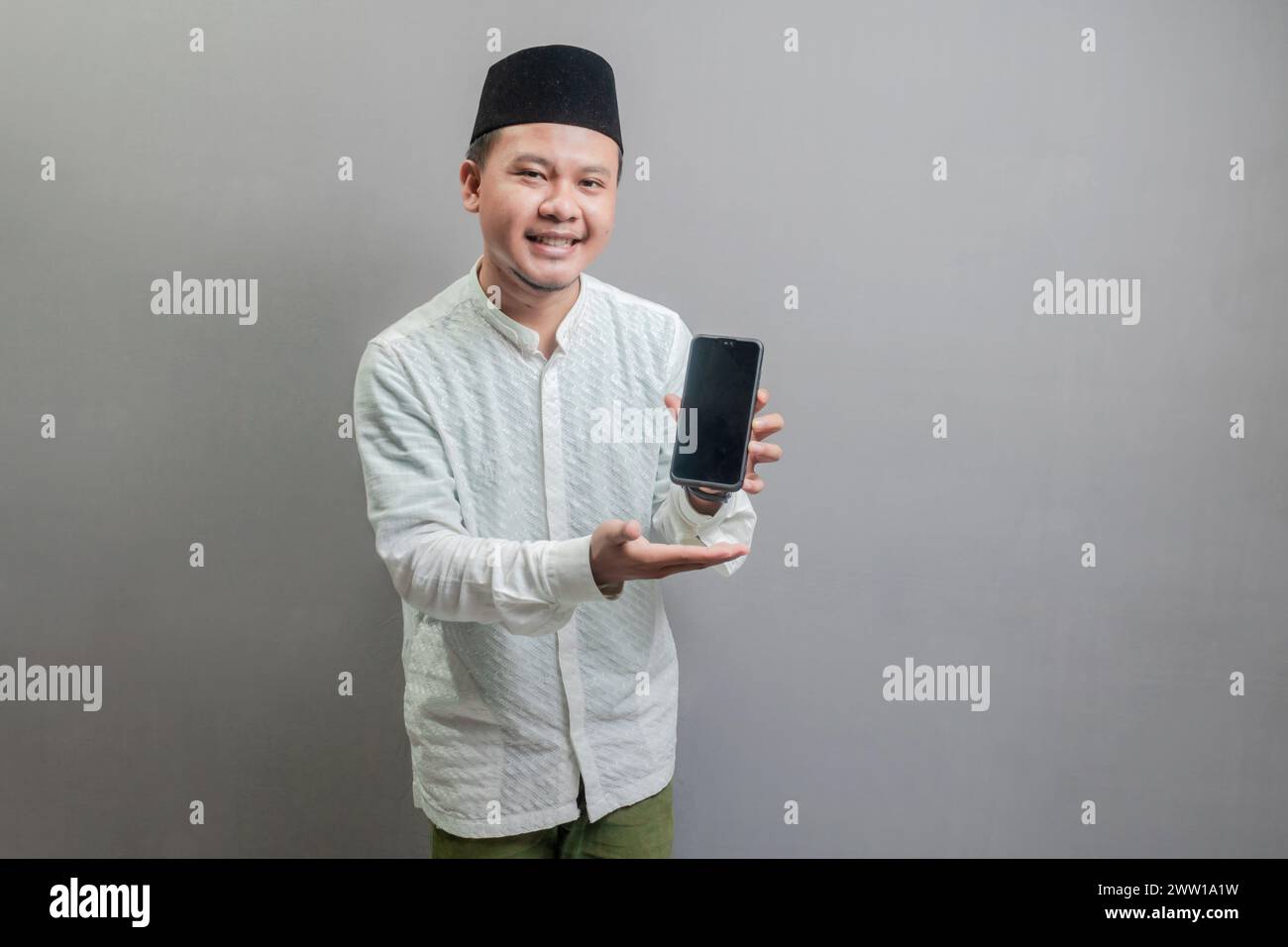 Happy asian muslim man showing smart phone cellphone for calls, social ...