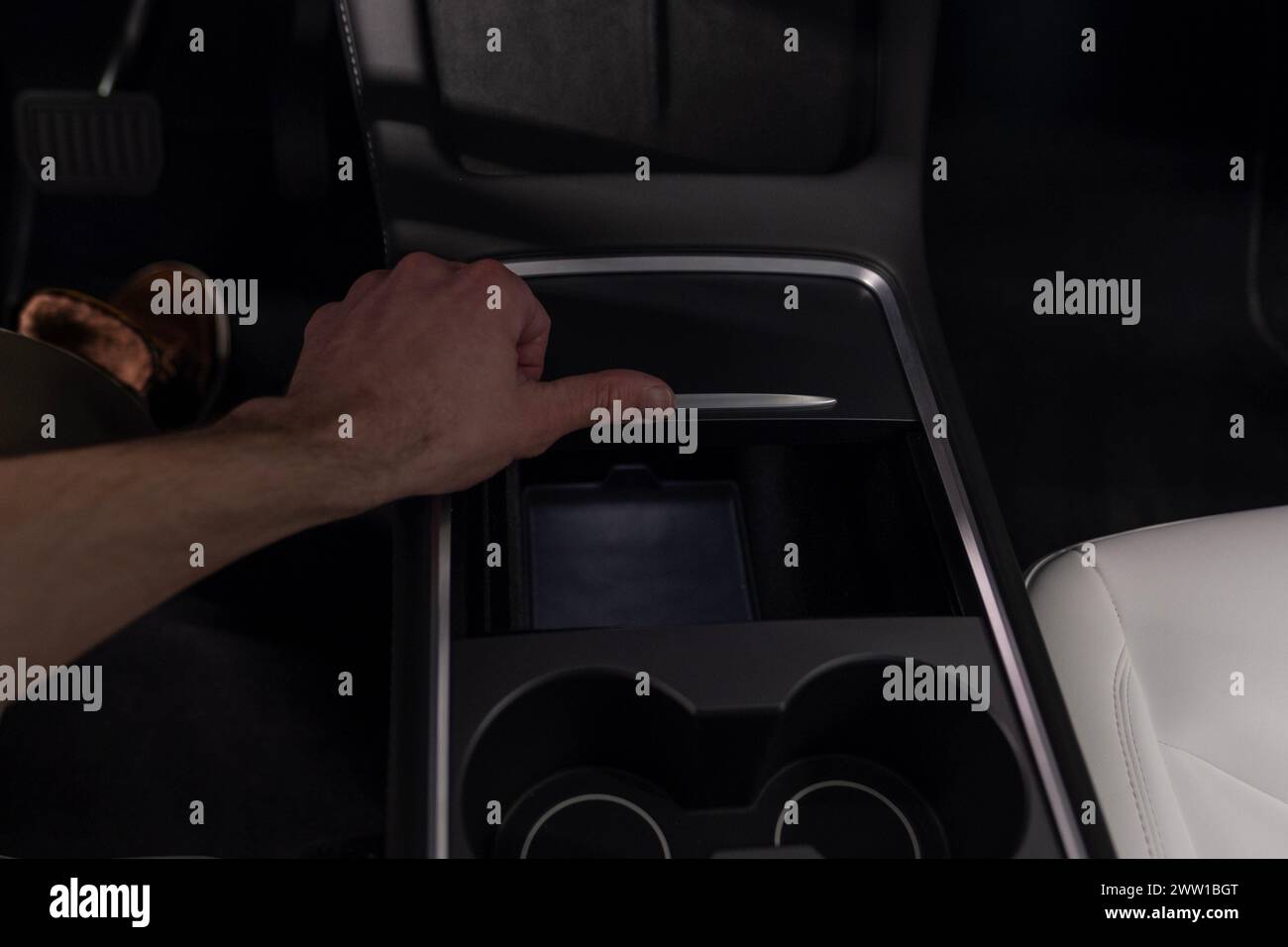 Interior Tesla model Y electric car, male hand on instrument panel ...
