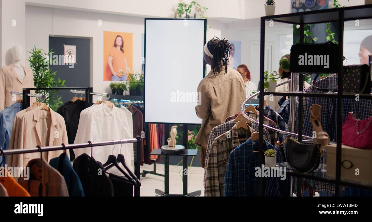 Customer in shopping outlet using AR tech kiosk to look at cheap and ...