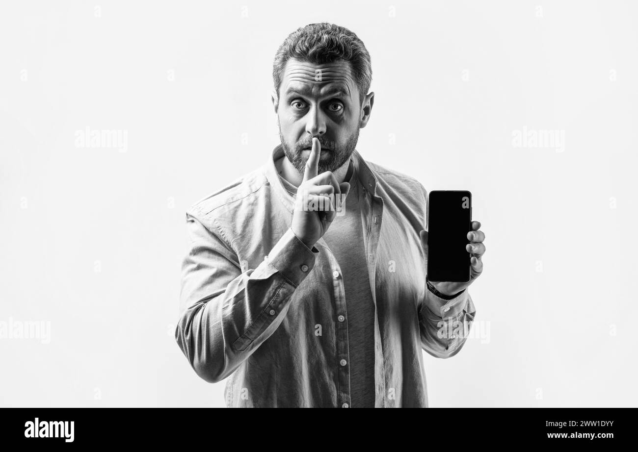 secret man showing phone app isolated on studio background. man showing ...
