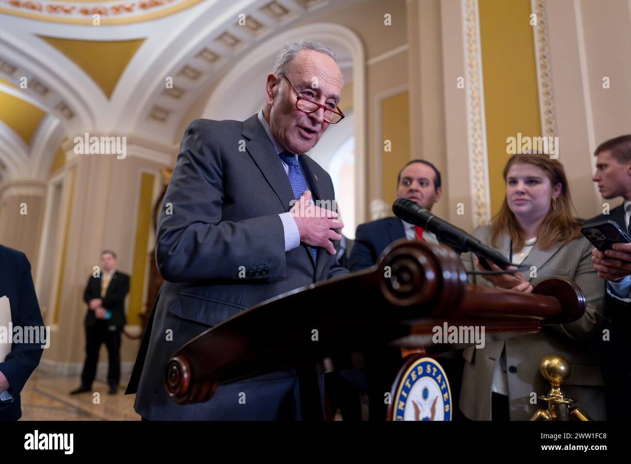 Senate Majority Leader Chuck Schumer, D-N.Y., places his hand over his ...