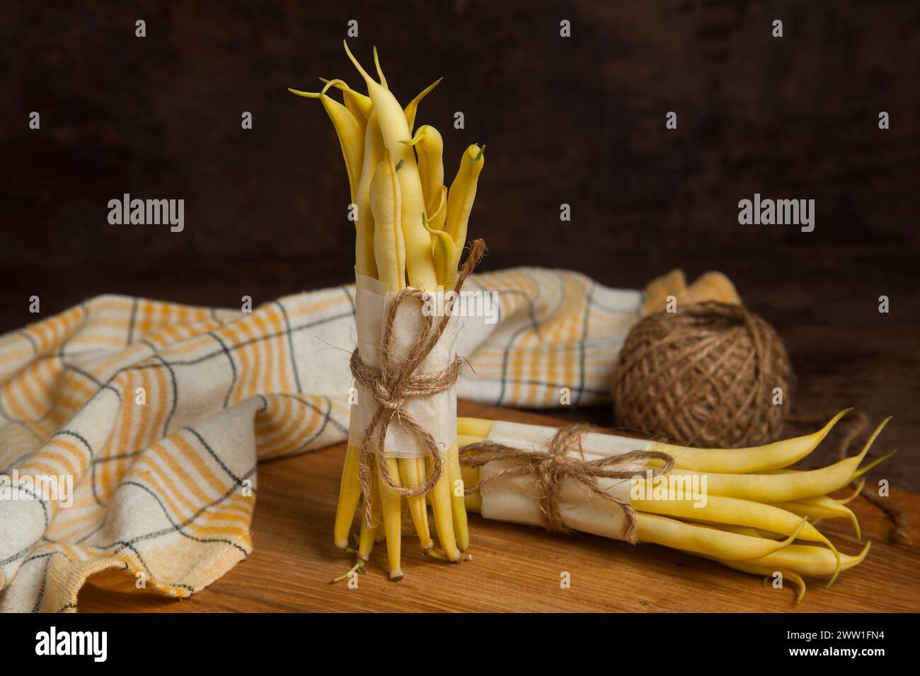 Cutting board with two bunch of raw yellow pods of haricot and yellow ...