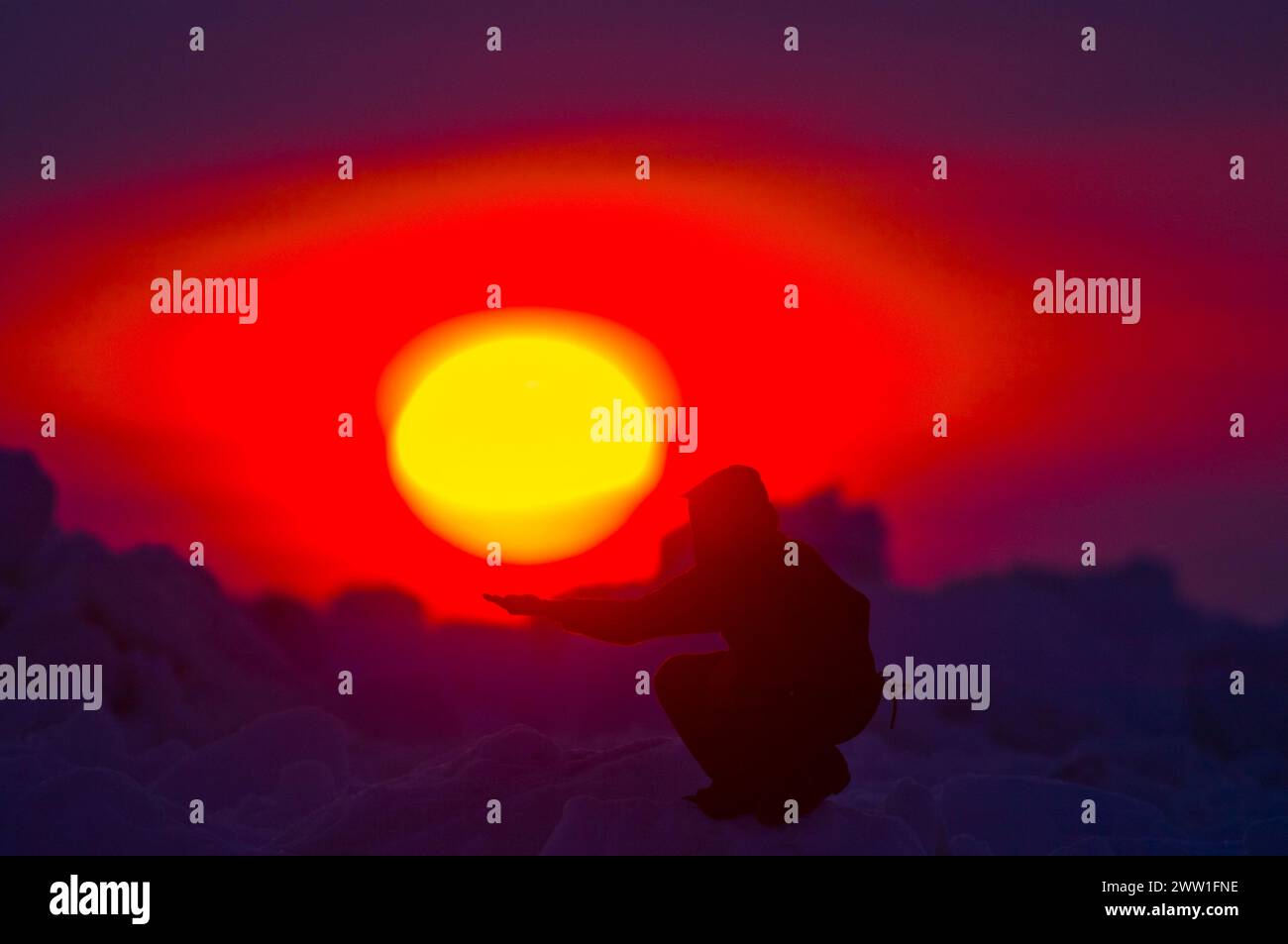 Inupiaq man hold his hand under the midnight sun in the Chukchi Sea ...