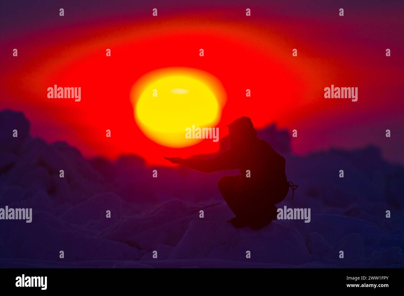 Inupiaq man hold his hand under the midnight sun in the Chukchi Sea ...