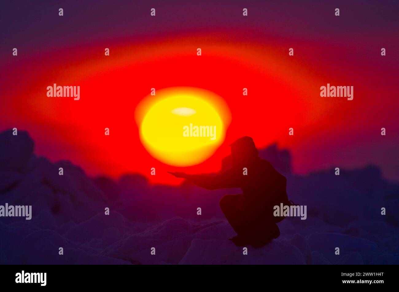 Inupiaq man hold his hand under the midnight sun in the Chukchi Sea ...