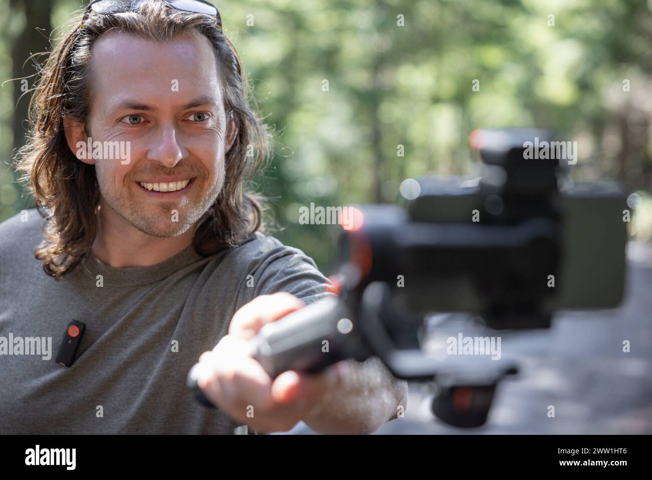 Content creator using. a phone gimbal to film in nature with a blurred ...