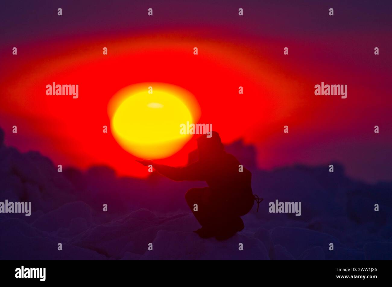 Inupiaq man hold his hand under the midnight sun in the Chukchi Sea ...