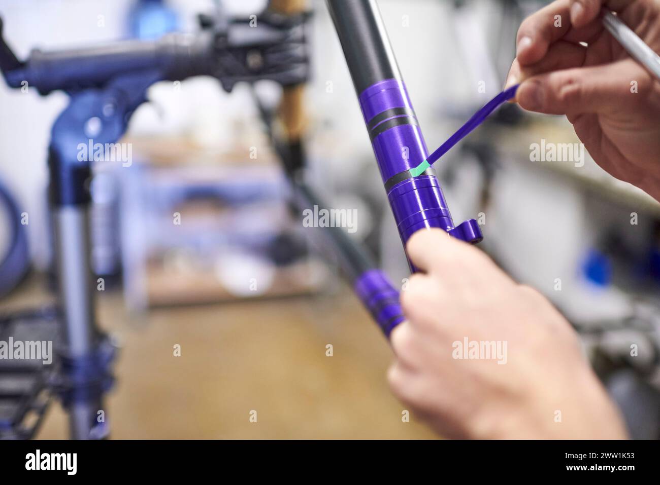 Unknown person working on a custom bike frame painting design in purple ...