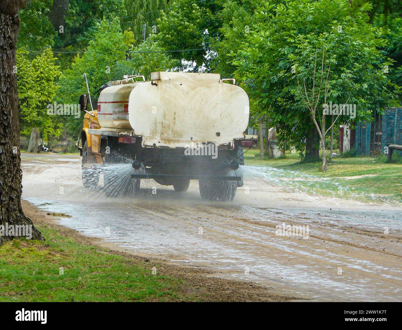 sprinkler truck on dirt road to avoid dust Stock Photo - Alamy