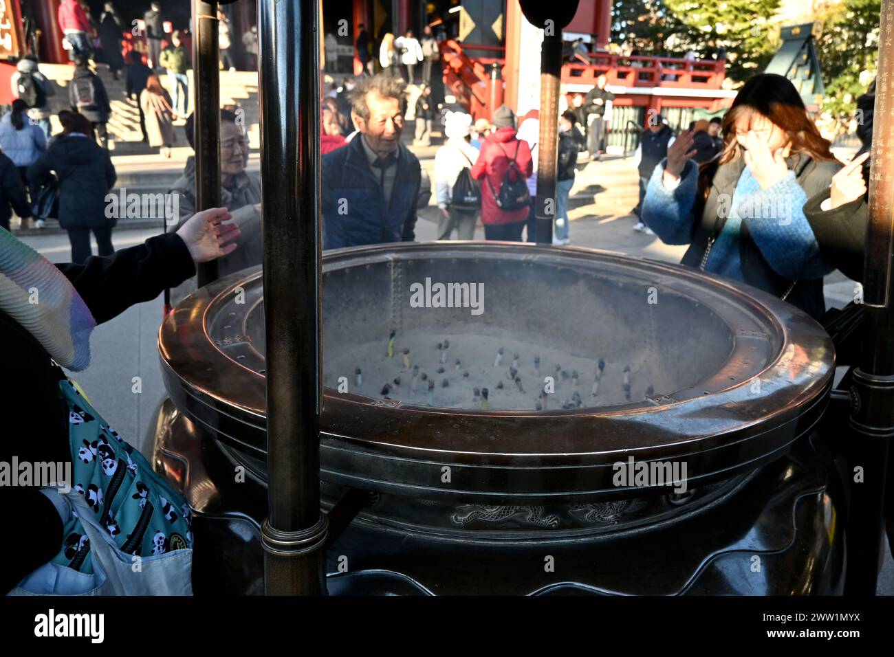 People gathered around incense burners in a Jokoro inside Sensō-ji ...