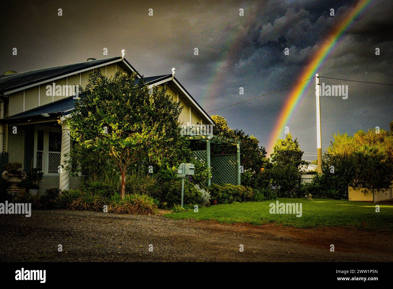 A rainbow emerges above a house post-storm Stock Photo - Alamy