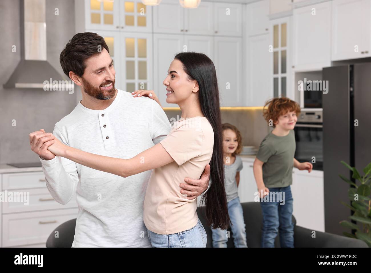 Happy family having fun at home. Couple dancing while children jumping ...