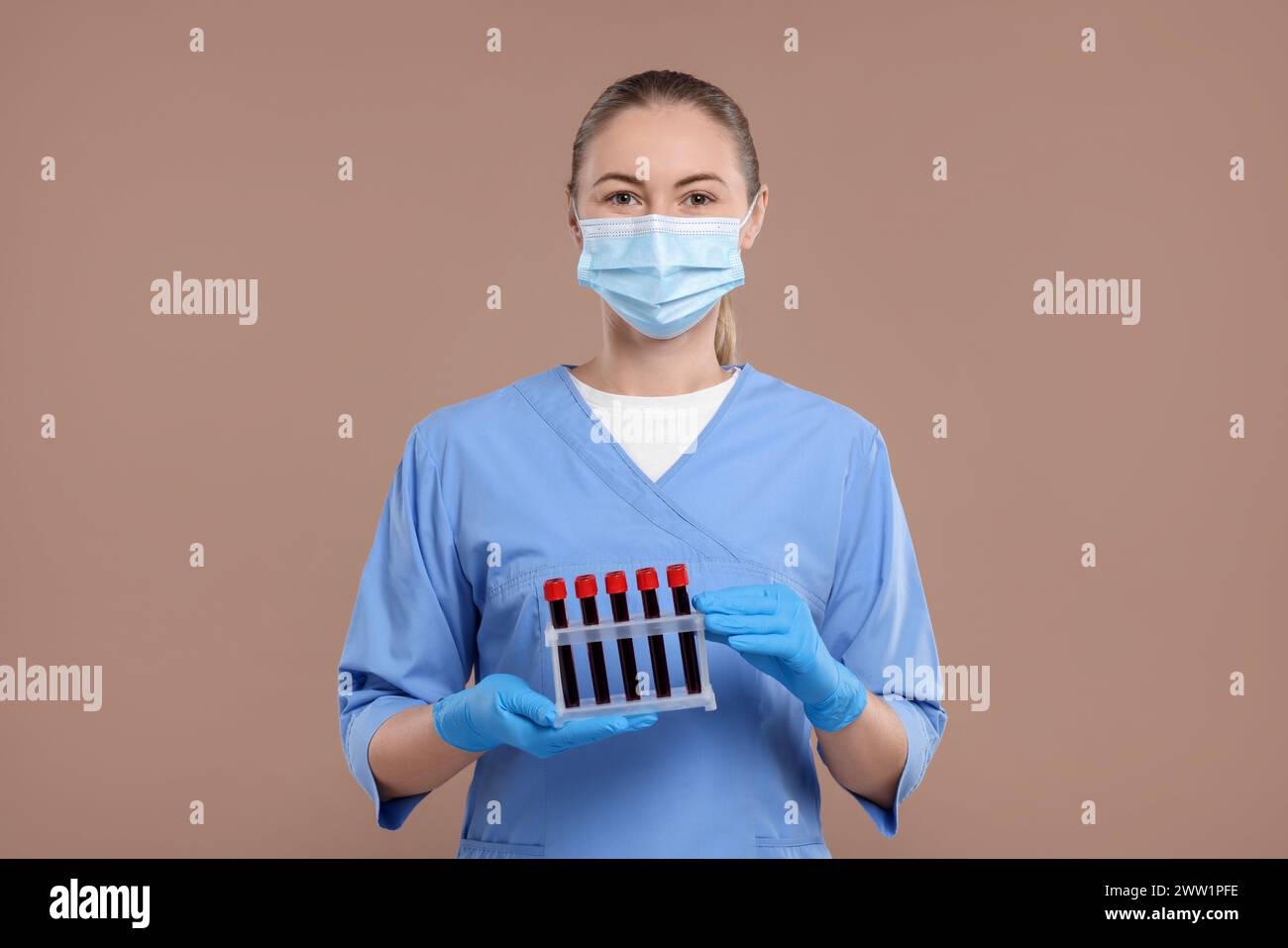 Laboratory testing. Doctor with blood samples in tubes on light brown ...