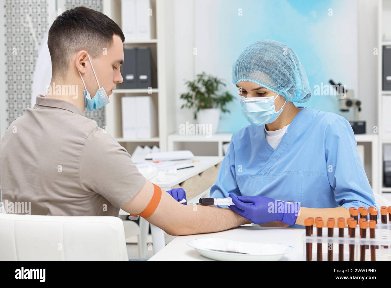 Laboratory testing. Doctor taking blood sample from patient at white ...